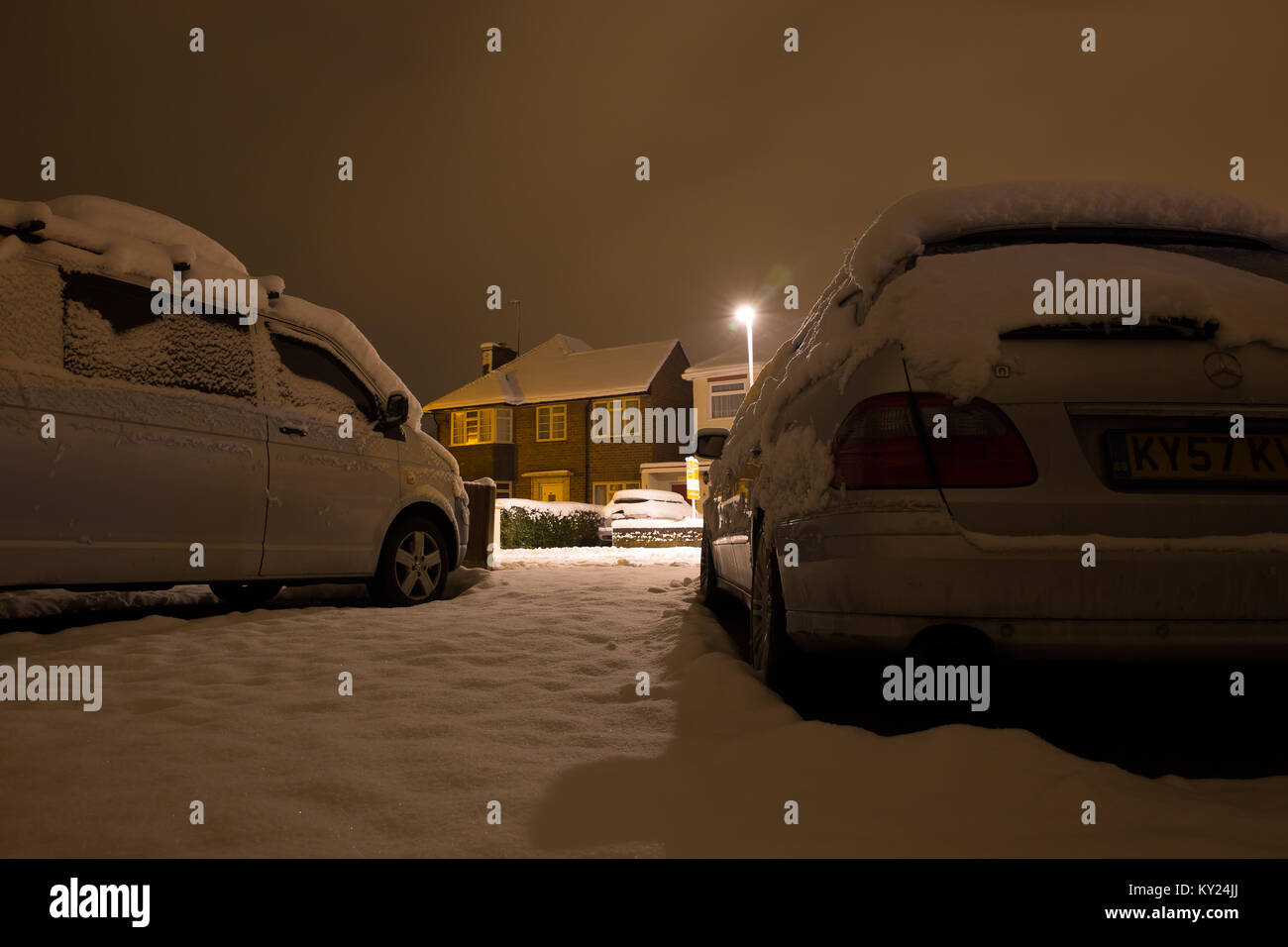 Snowy street scene on a cold December evening, taken from the driveway ...