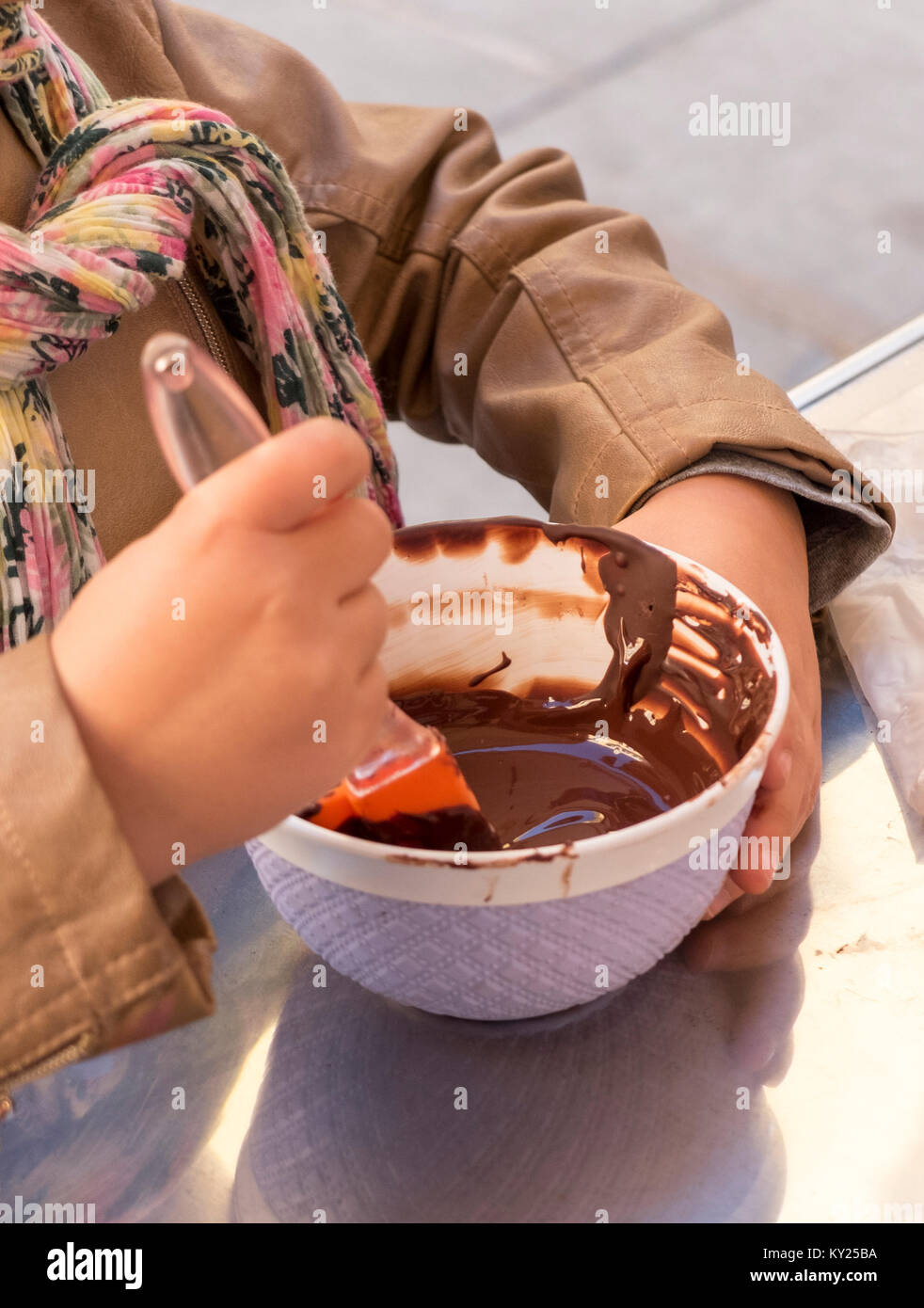 hands of a child play the pastry chef mixing chocolate in a bowl before ...