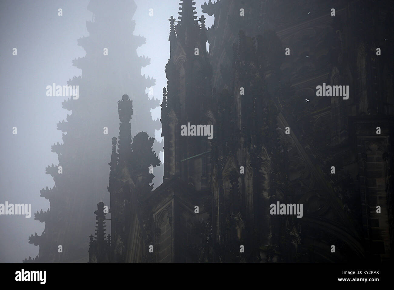 Cologne, Germany. 12th Jan, 2018. Wafts of mist pass the towers of the ...