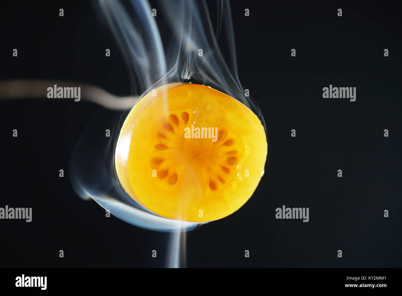 A tomato sliced and photographed in front of flash in the studio Stock ...