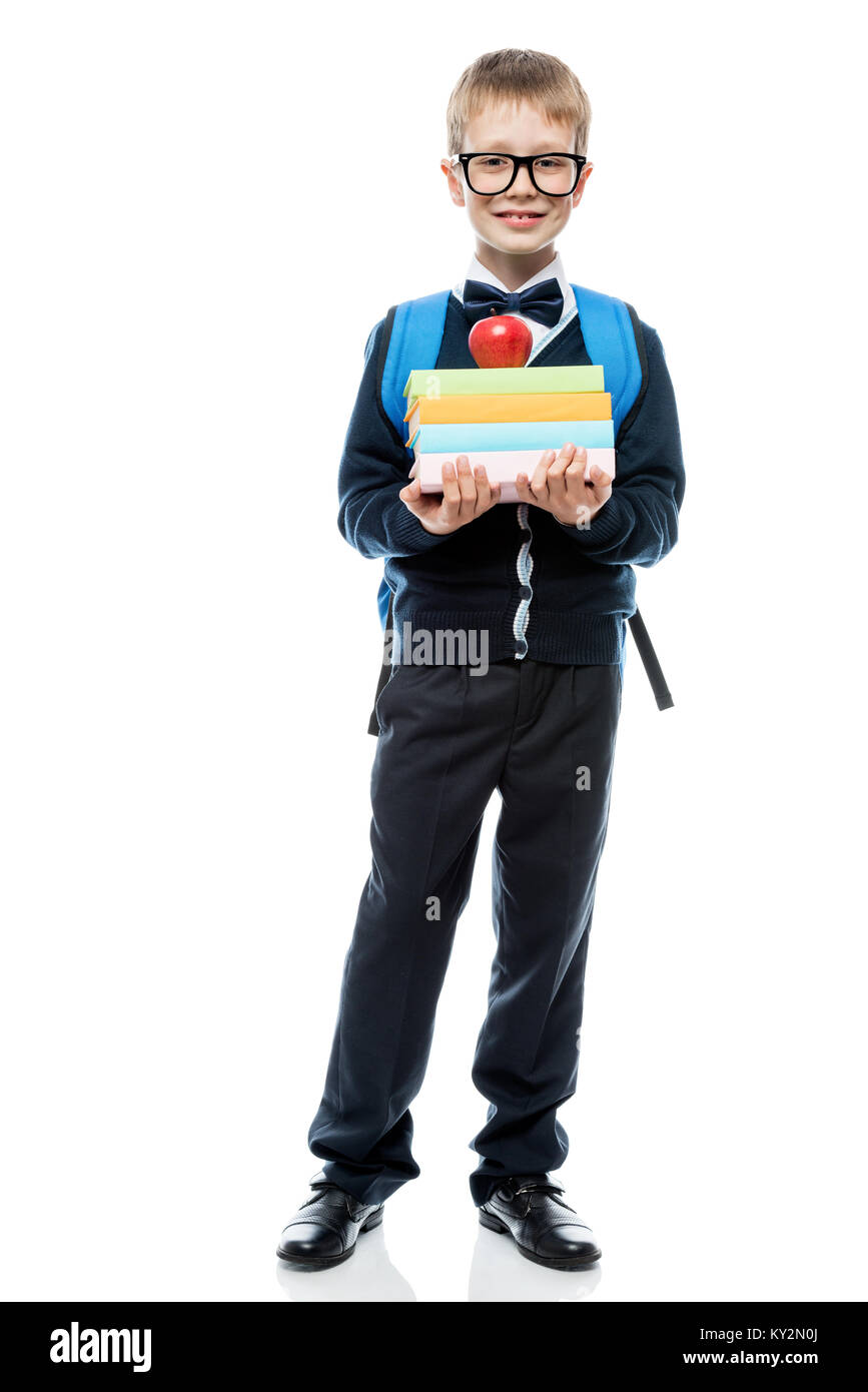 smart schoolboy with a pile of books and a red apple in full length on ...