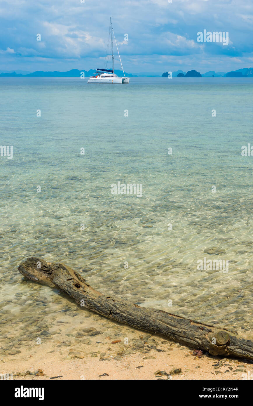 focus on a log in the sea vertical landscape - sea, yacht and mountains ...