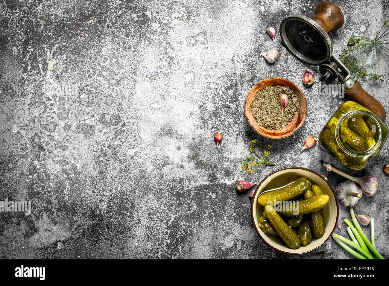 Pickled cucumbers with seamer. On a rustic background Stock Photo - Alamy