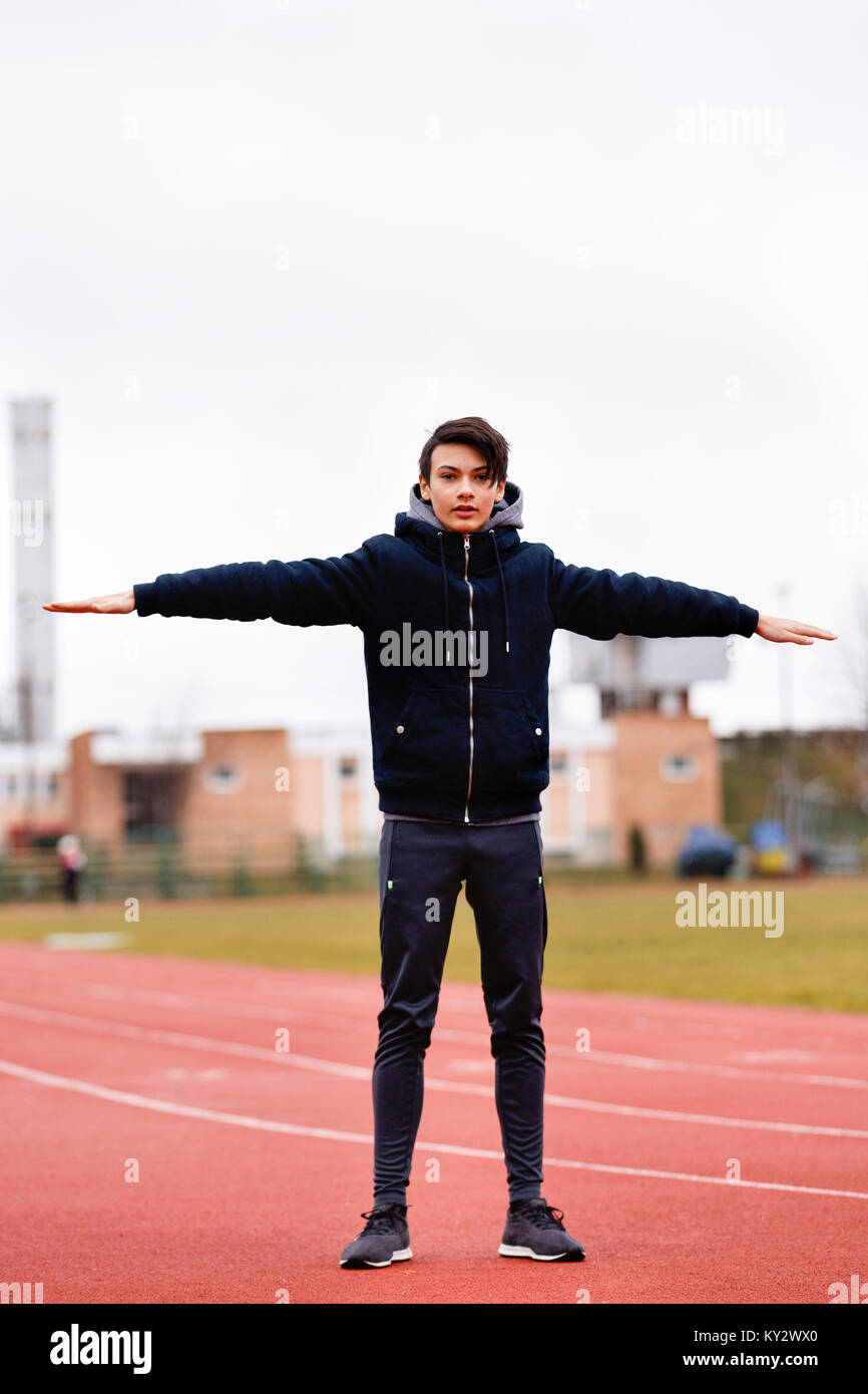 young sportsman makes exercises on a running track Stock Photo - Alamy