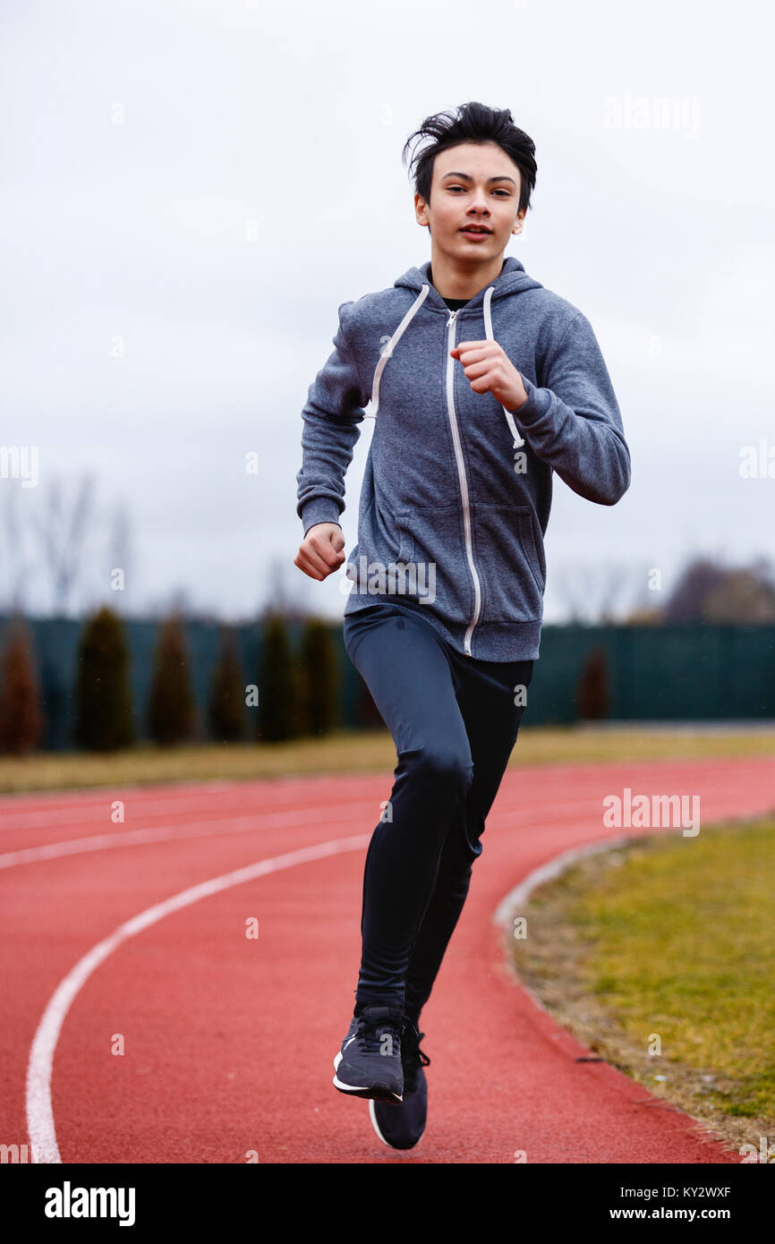 Athlete Asian young man running on racetrack in stadium. Healthy active ...