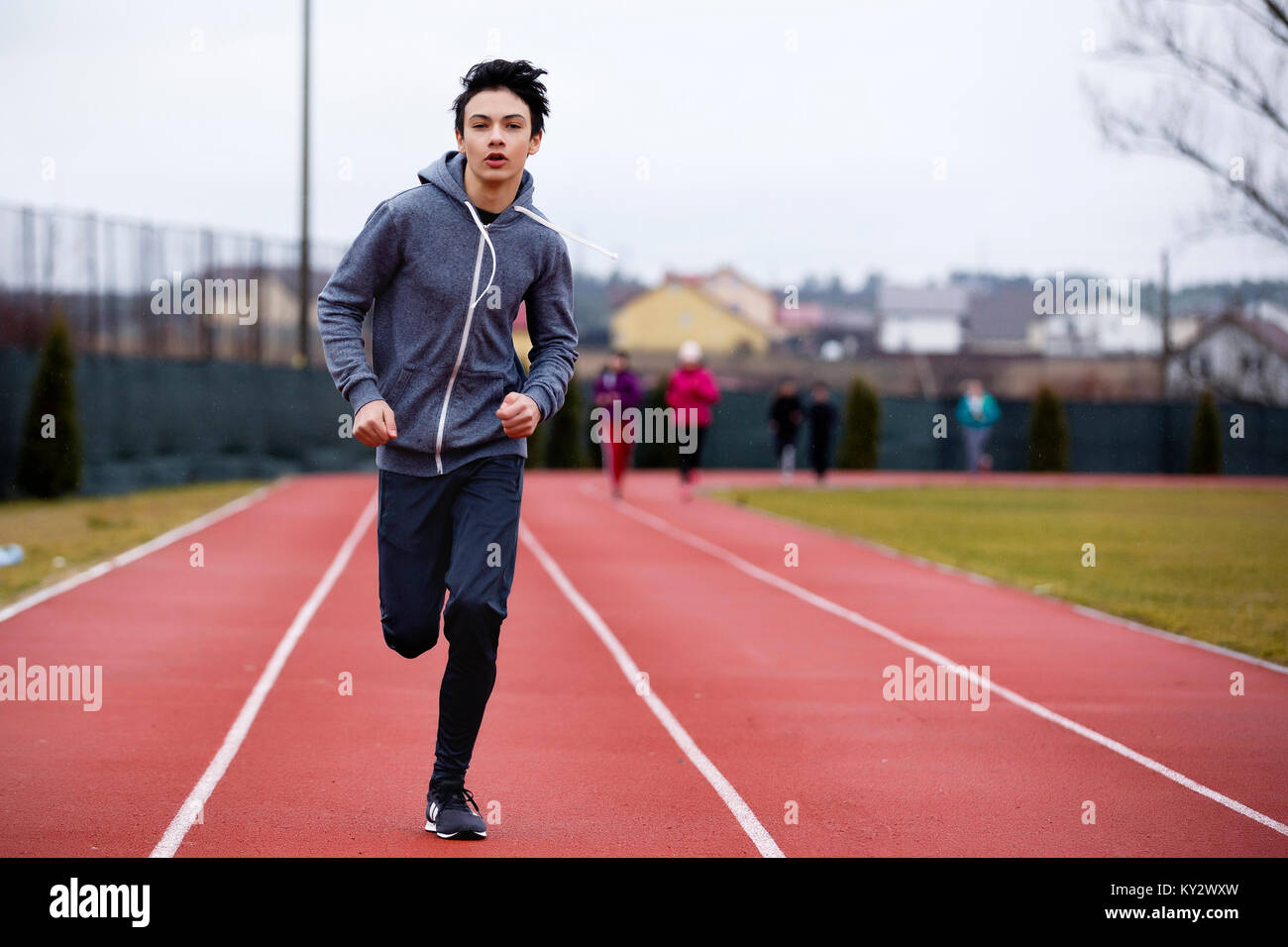 Athlete Asian young man running on racetrack in stadium. Healthy active ...