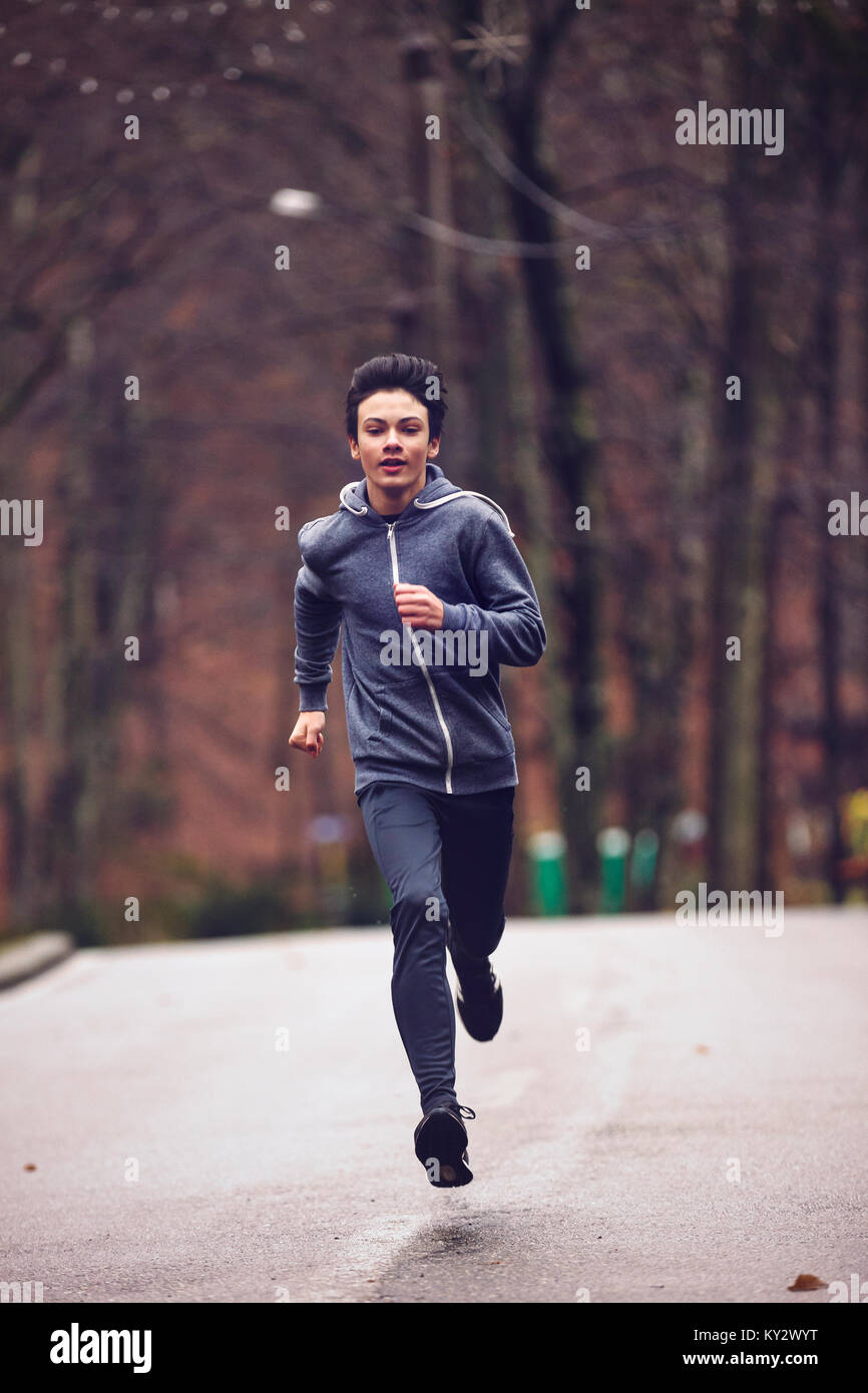 young man running in the park during the rain Stock Photo - Alamy