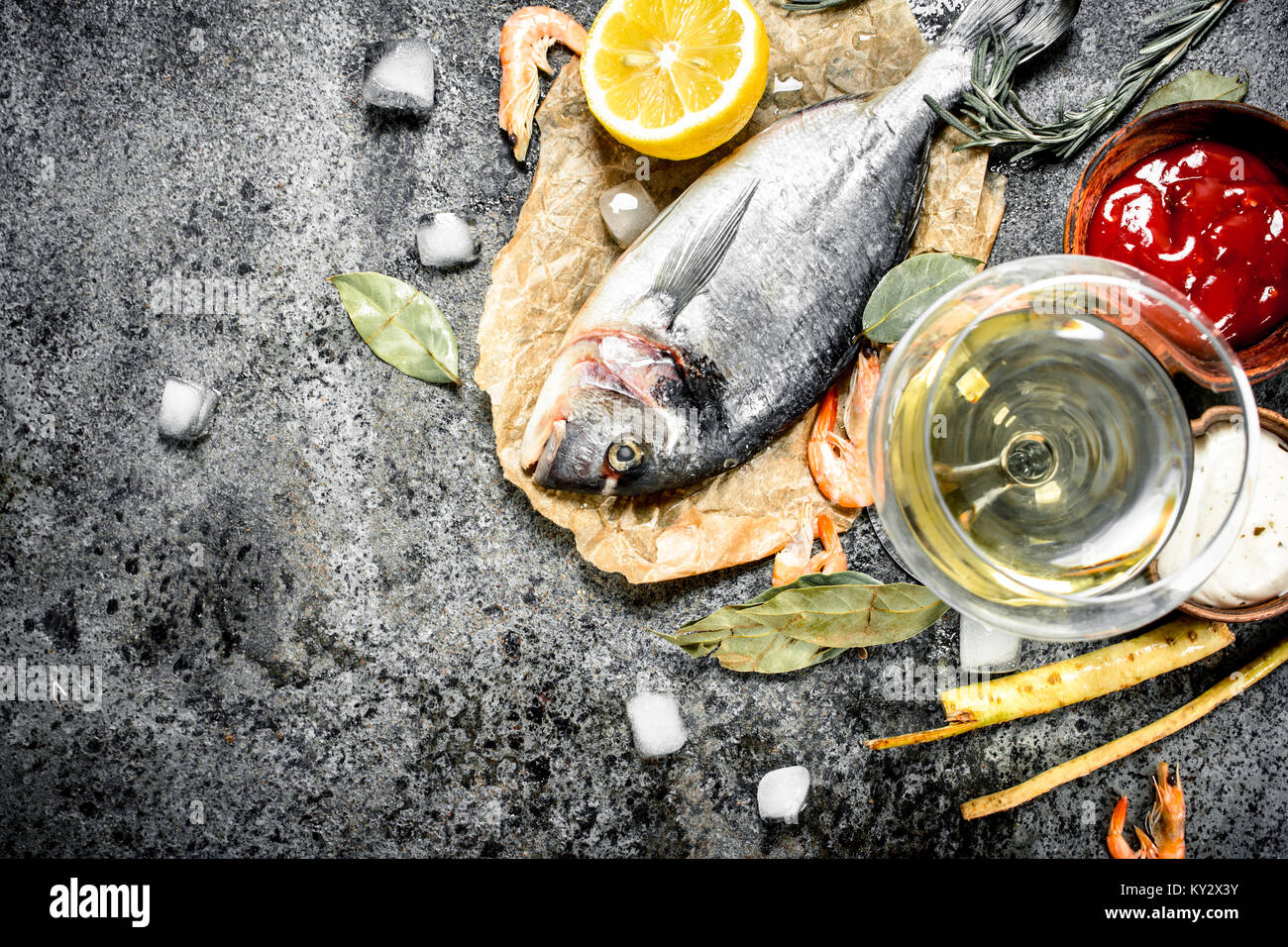 Unprocessed Dorado fish with spices and lemon. On a rustic background ...