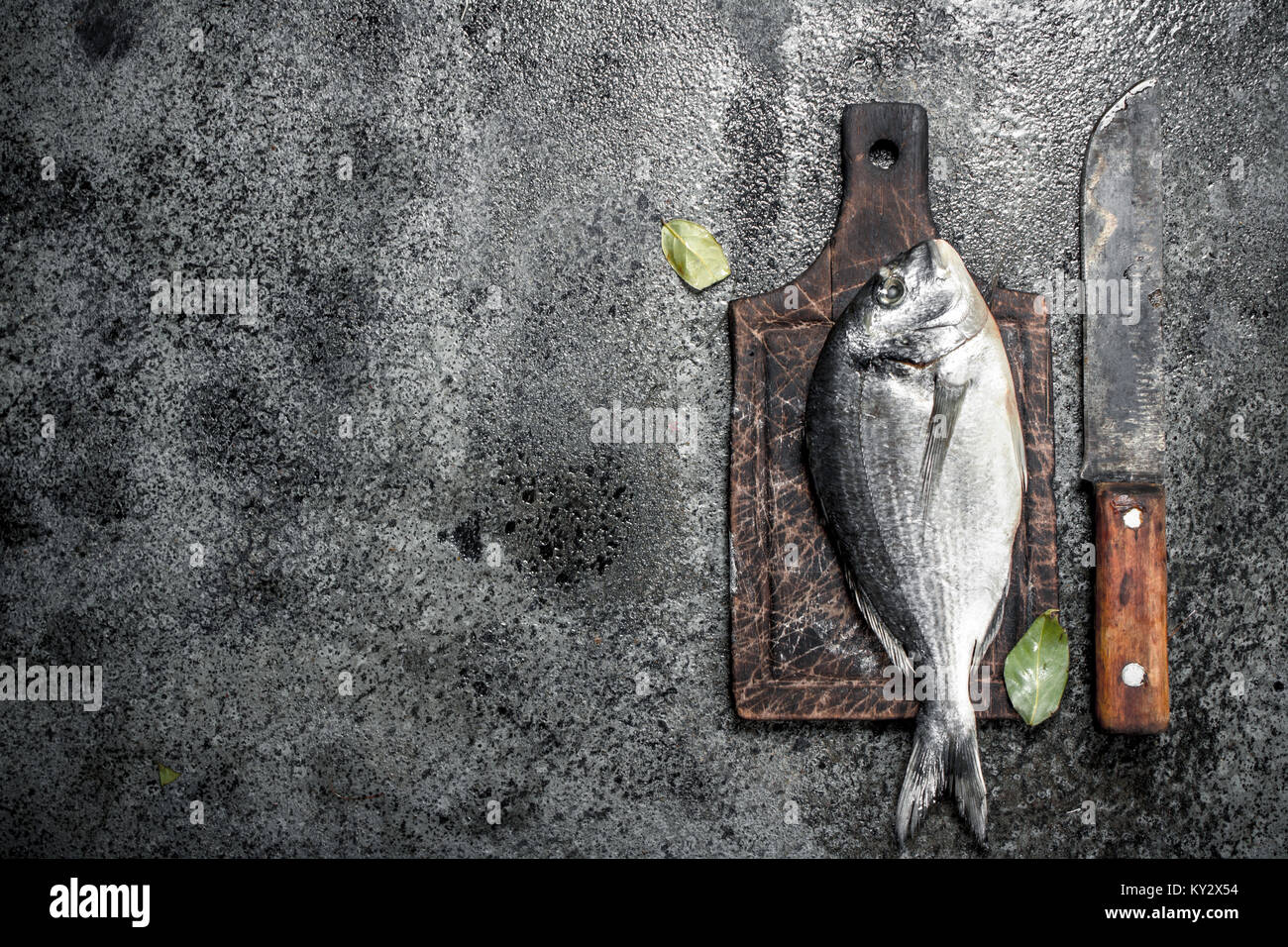 Fresh unprepared dorado fish on a board. On a rustic background Stock ...
