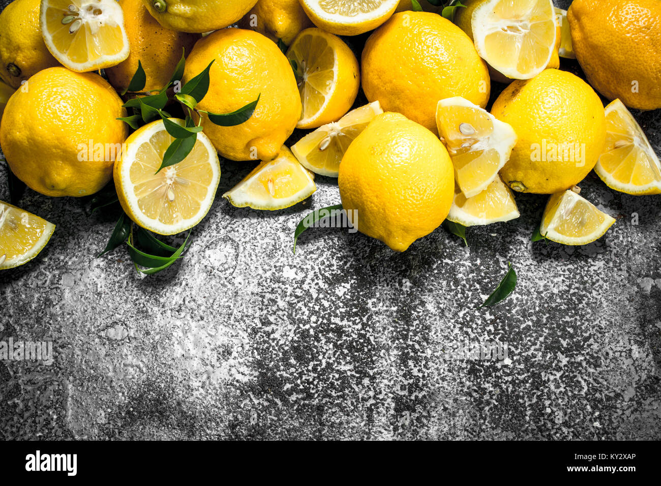 Fresh lemons with leaves. On a rustic background Stock Photo - Alamy