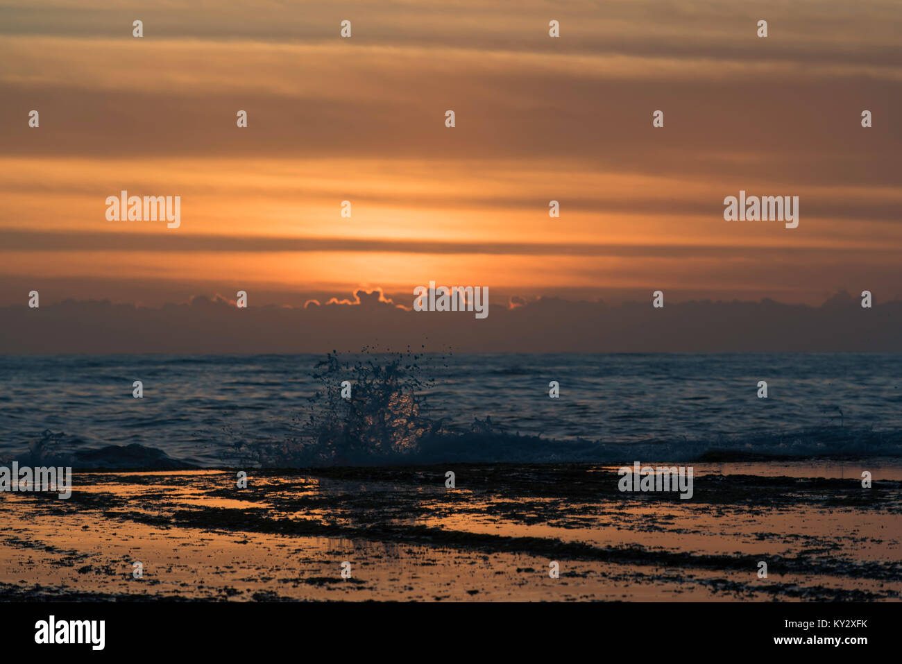 A pre dawn view over a rock ledge to the ocean on the east coast of ...