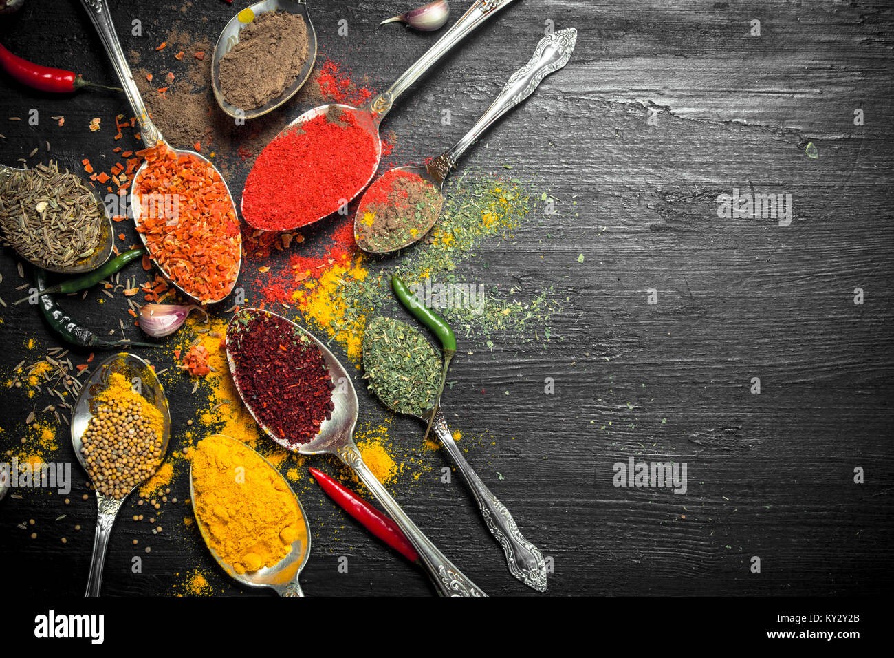 Ground spices and herbs in spoons. On the black chalkboard Stock Photo ...