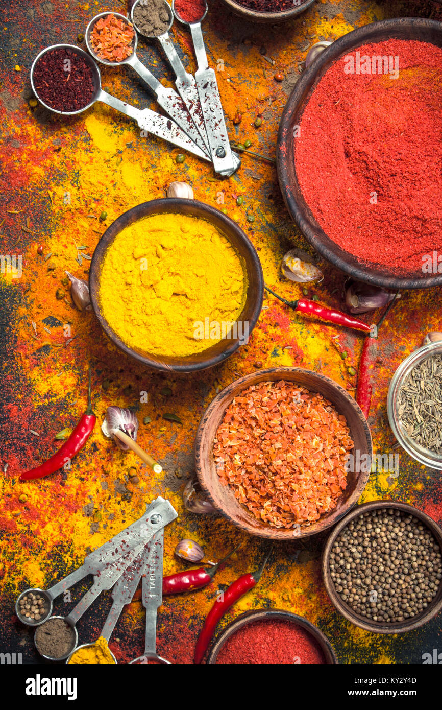 Spicy spices in bowls with measuring spoons. Top view Stock Photo - Alamy