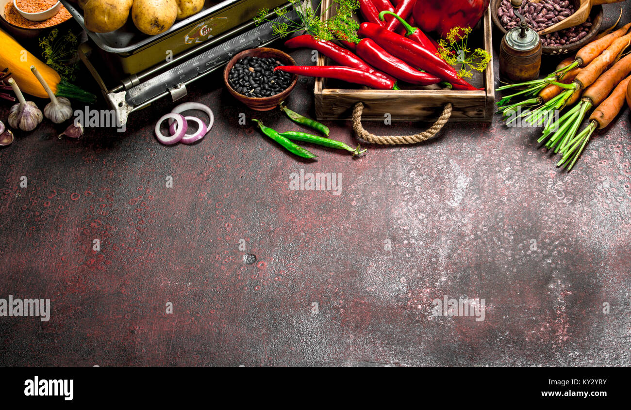 Organic food. Fresh crop of legumes and vegetables. On a rustic ...