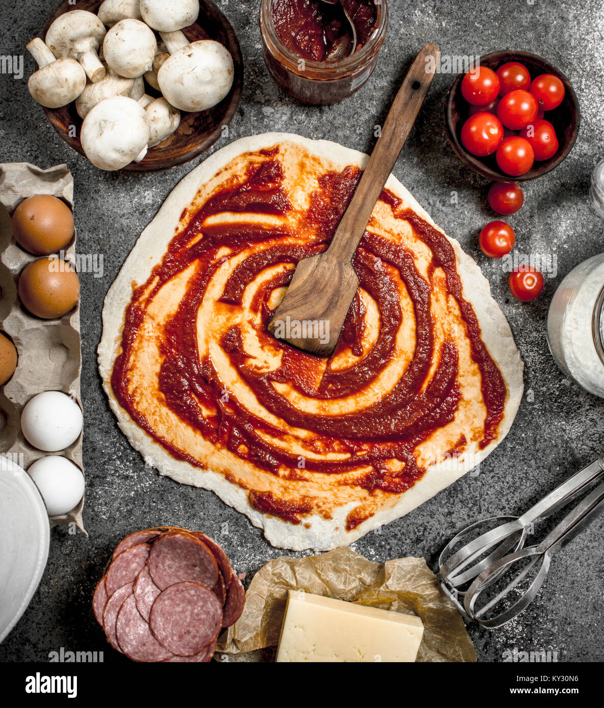 Roll up dough with tomato sauce and various ingredients. On a rustic ...