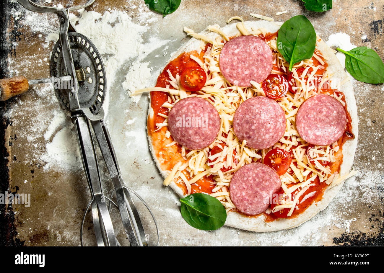 Unprepared pizza with ingredients. On a rustic background Stock Photo ...