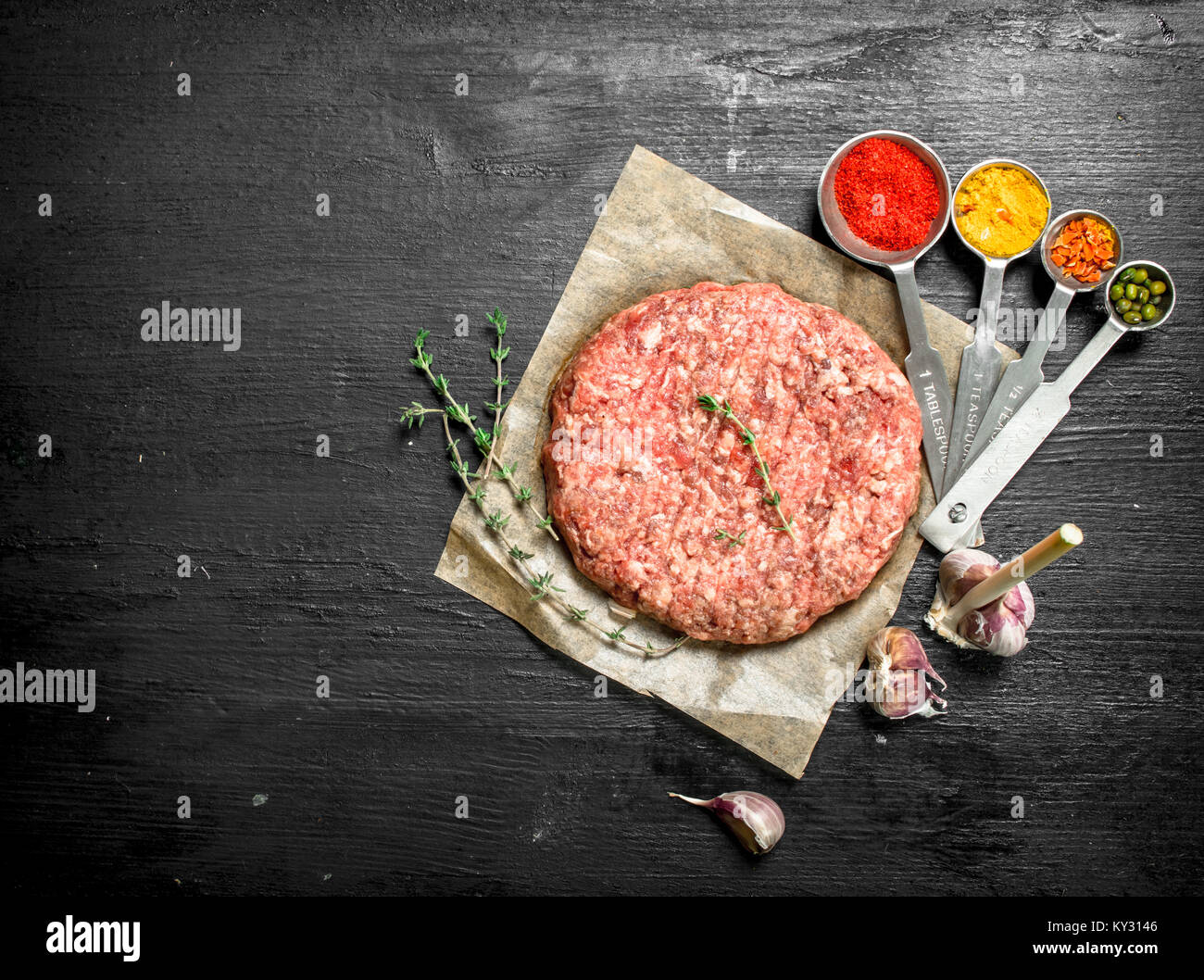 Raw burger with spices and herbs. On the black chalkboard Stock Photo ...