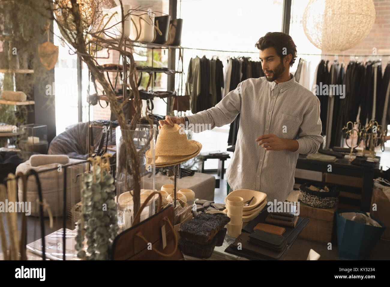 Man selecting hats in boutique shop Stock Photo - Alamy
