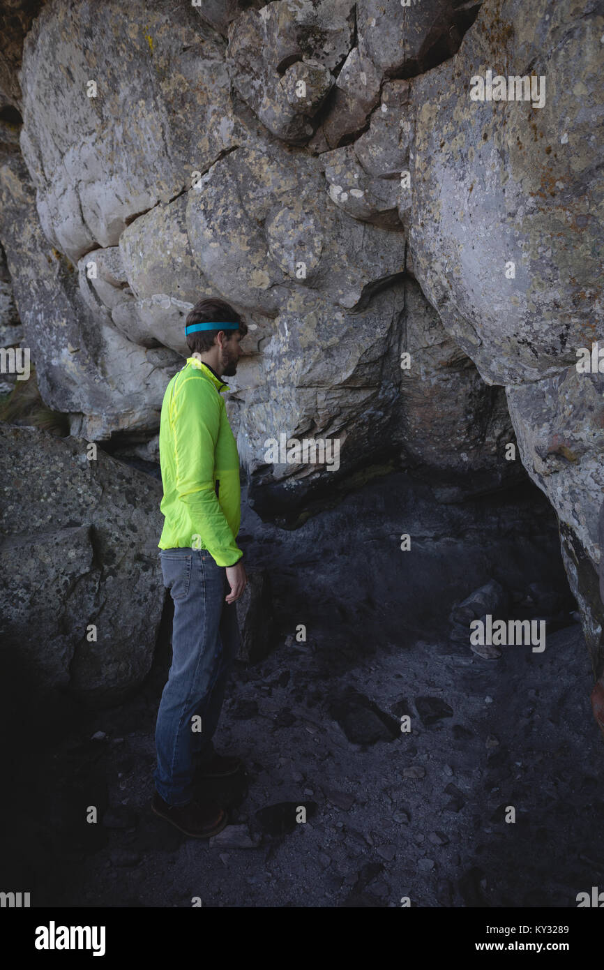 Hiker standing at cave entrance Stock Photo - Alamy