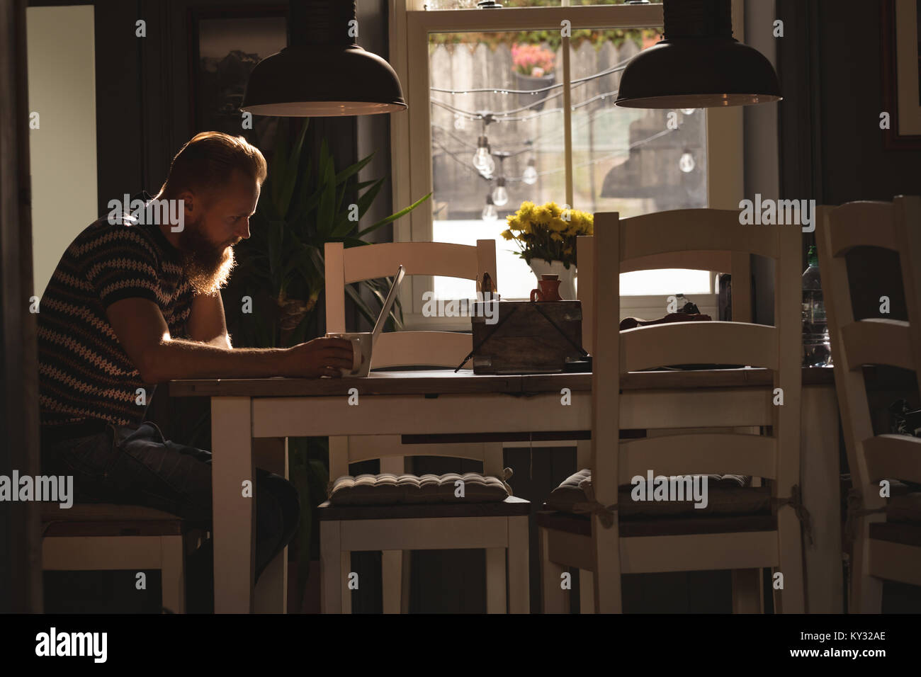 Man sitting on chair using his laptop Stock Photo - Alamy