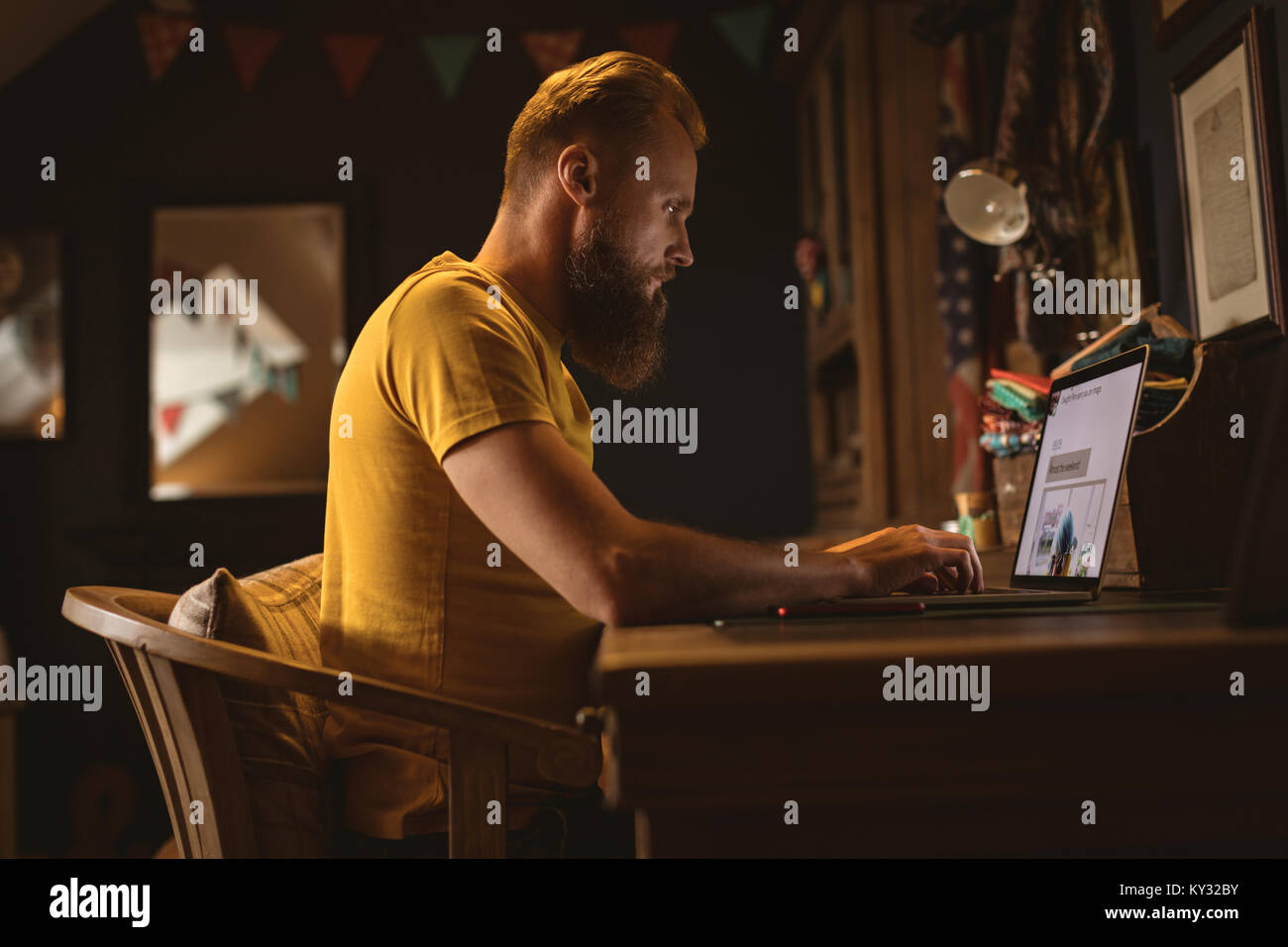 Man sitting on chair using his laptop Stock Photo - Alamy