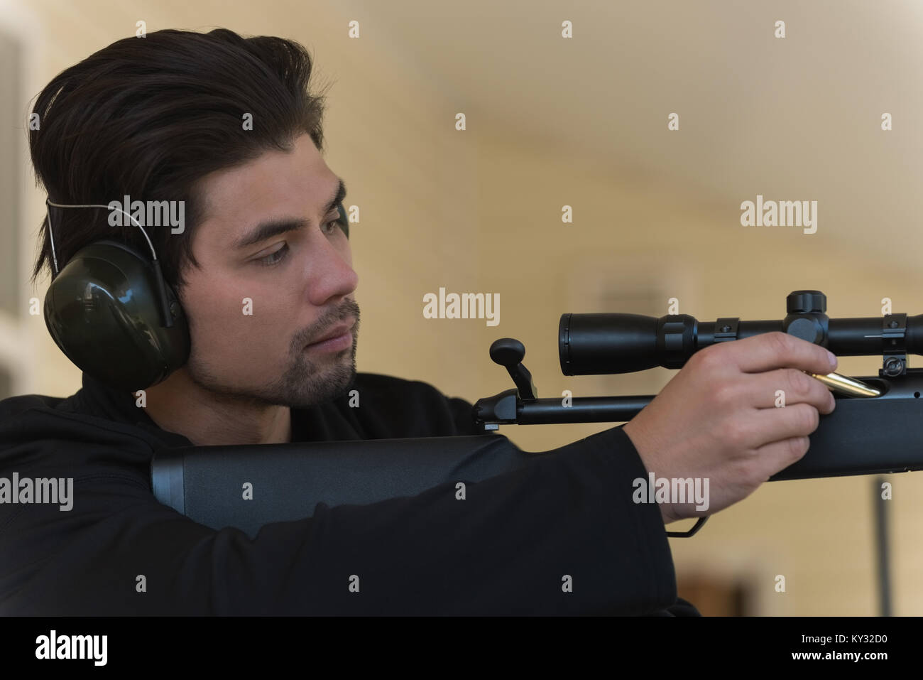 Man loading bullet into sniper rifle Stock Photo - Alamy