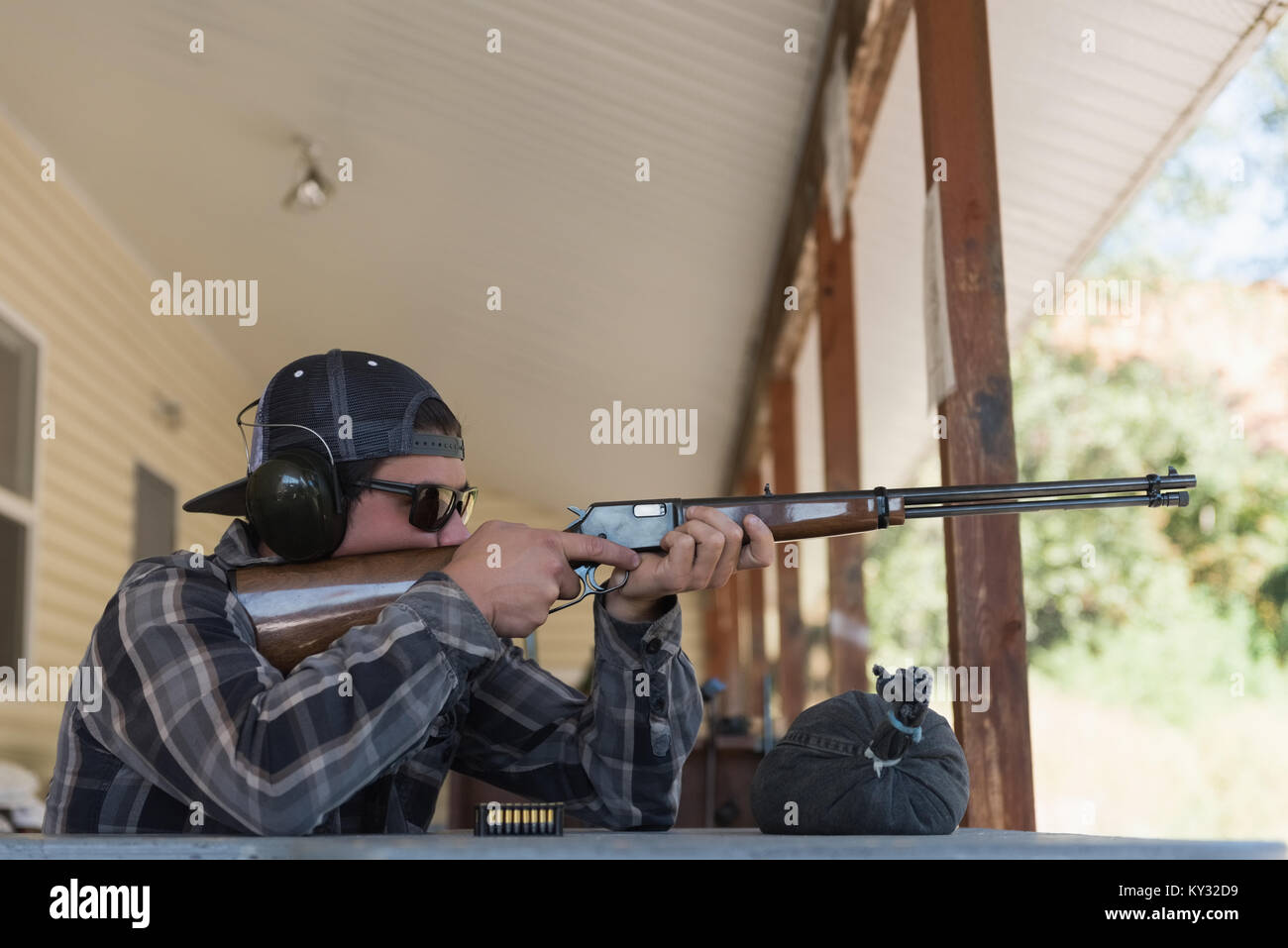 Man aiming shotgun at target in shooting range Stock Photo - Alamy