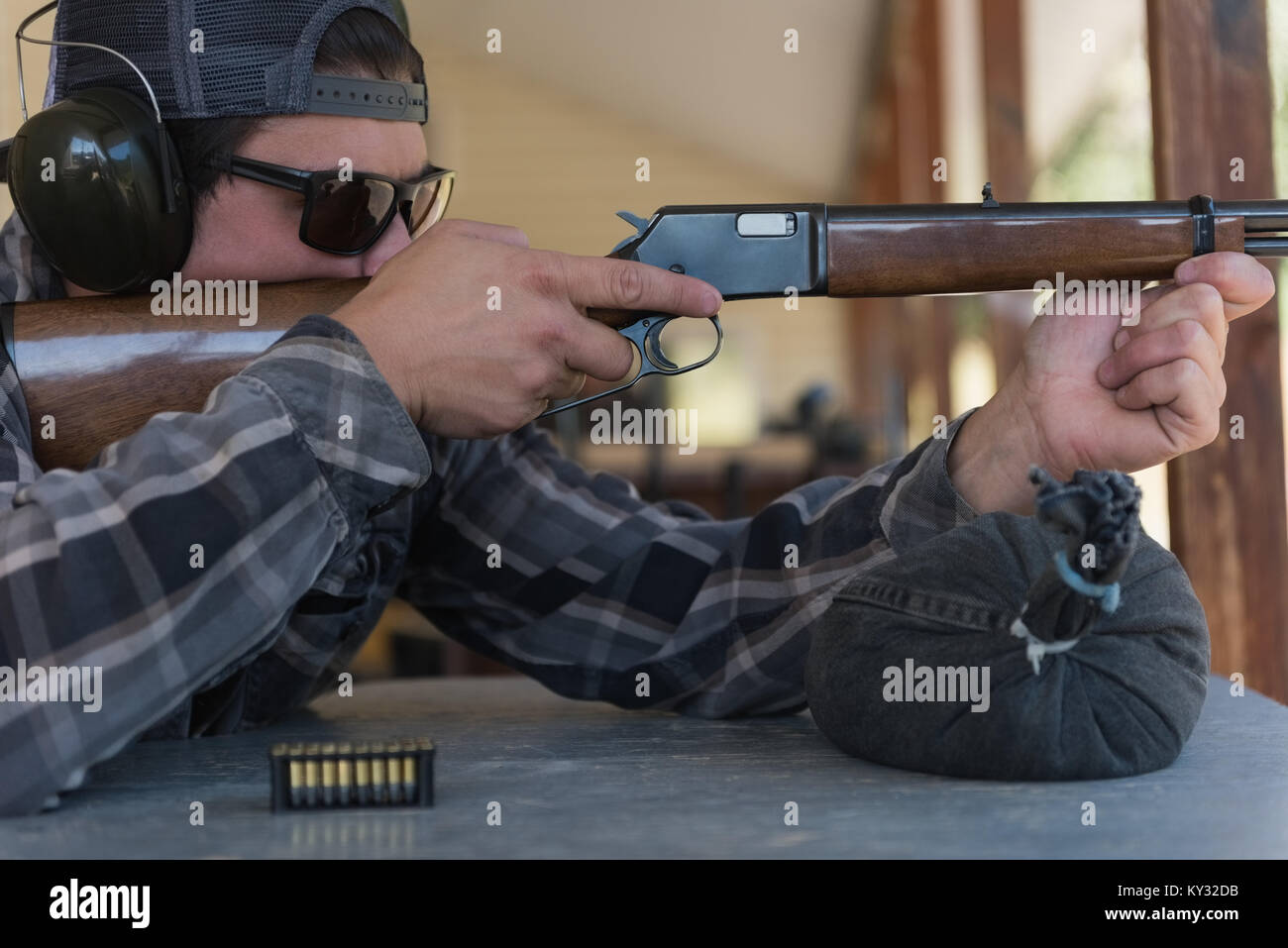 Man aiming shotgun at target in shooting range Stock Photo - Alamy