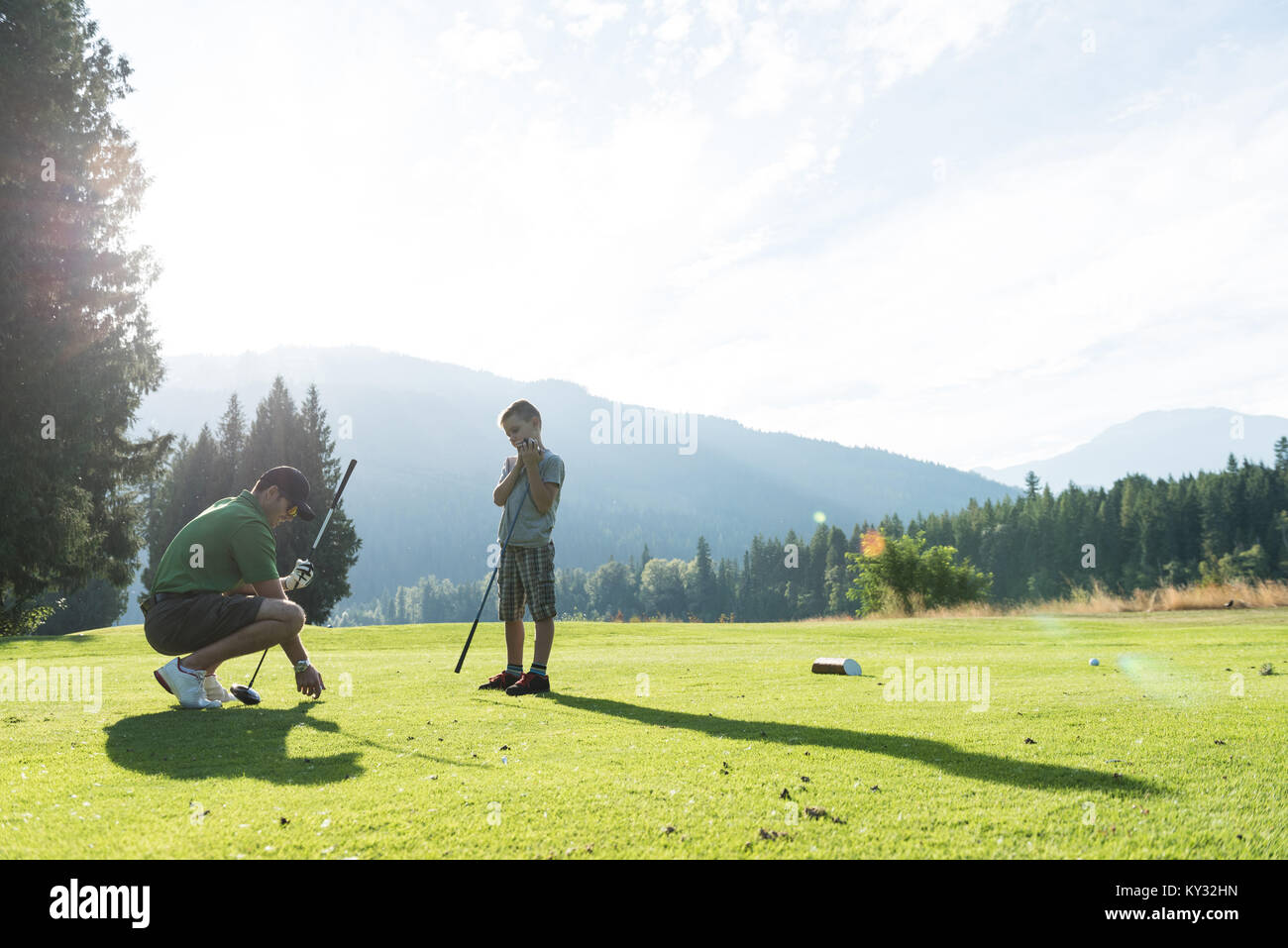 Father adjusting golf ball on tee Stock Photo - Alamy