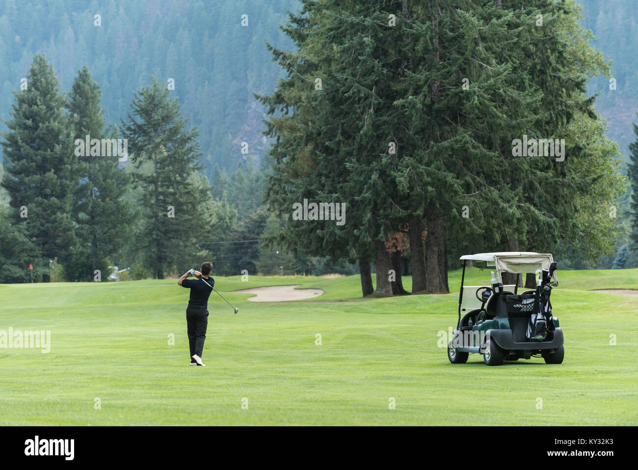 Golfer hitting a golf shot Stock Photo - Alamy