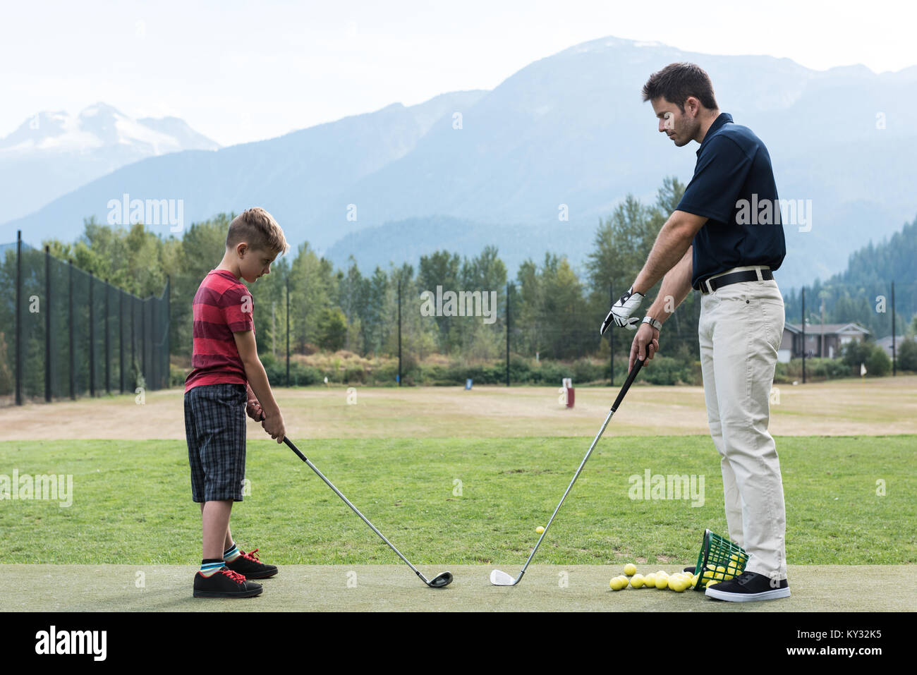 Father assisting his son to play golf Stock Photo - Alamy