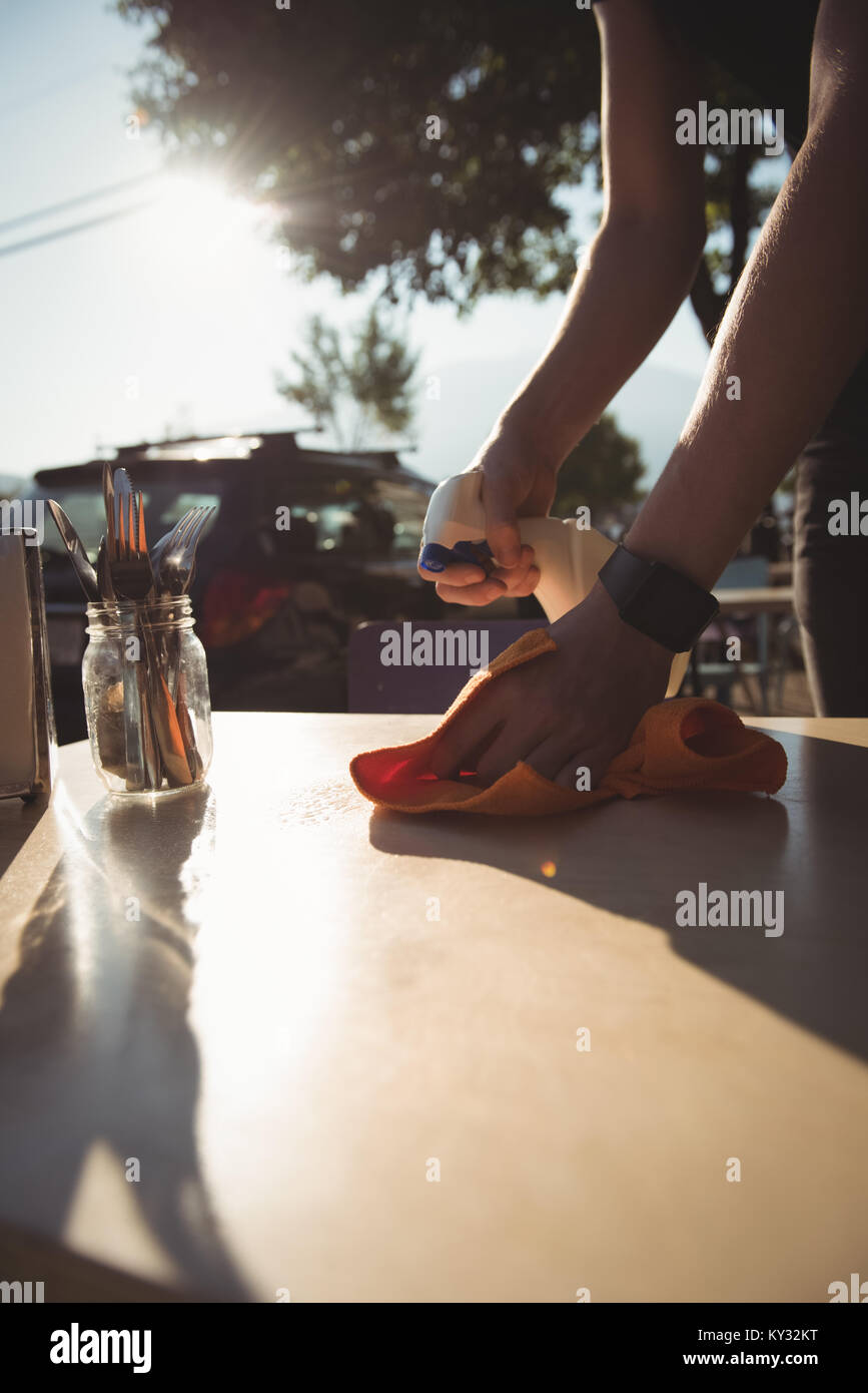 Mid section of worker cleaning table Stock Photo - Alamy