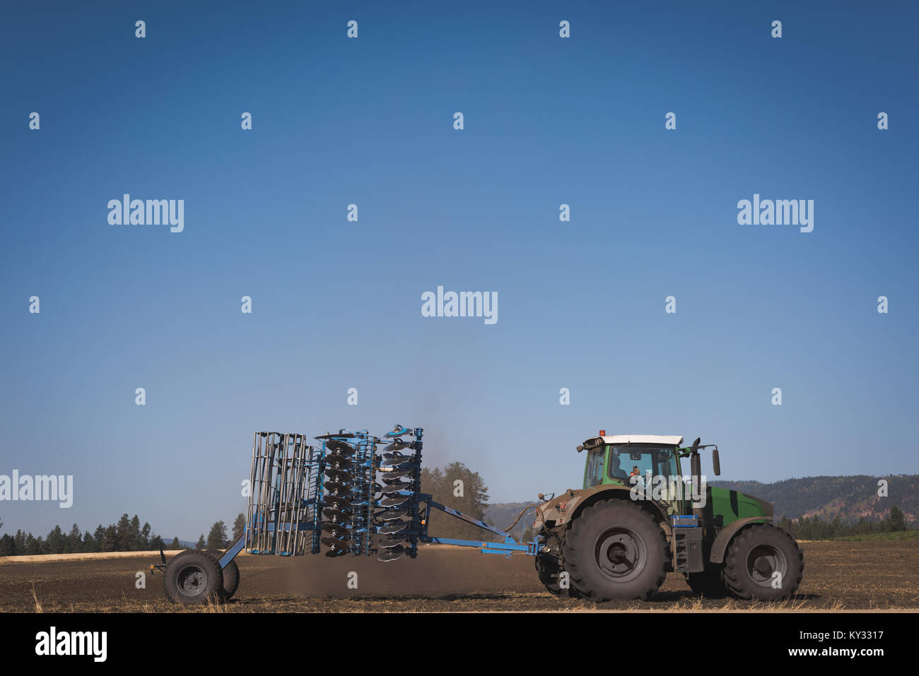 Tractor sprinkling fertilizer in field Stock Photo - Alamy