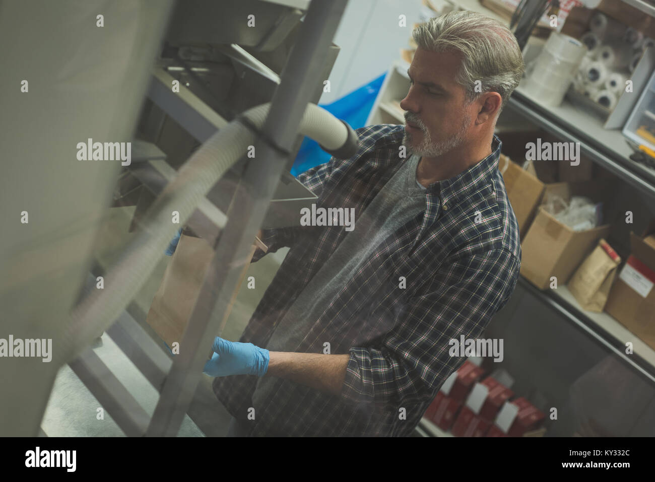 Man refining grain in machine Stock Photo - Alamy