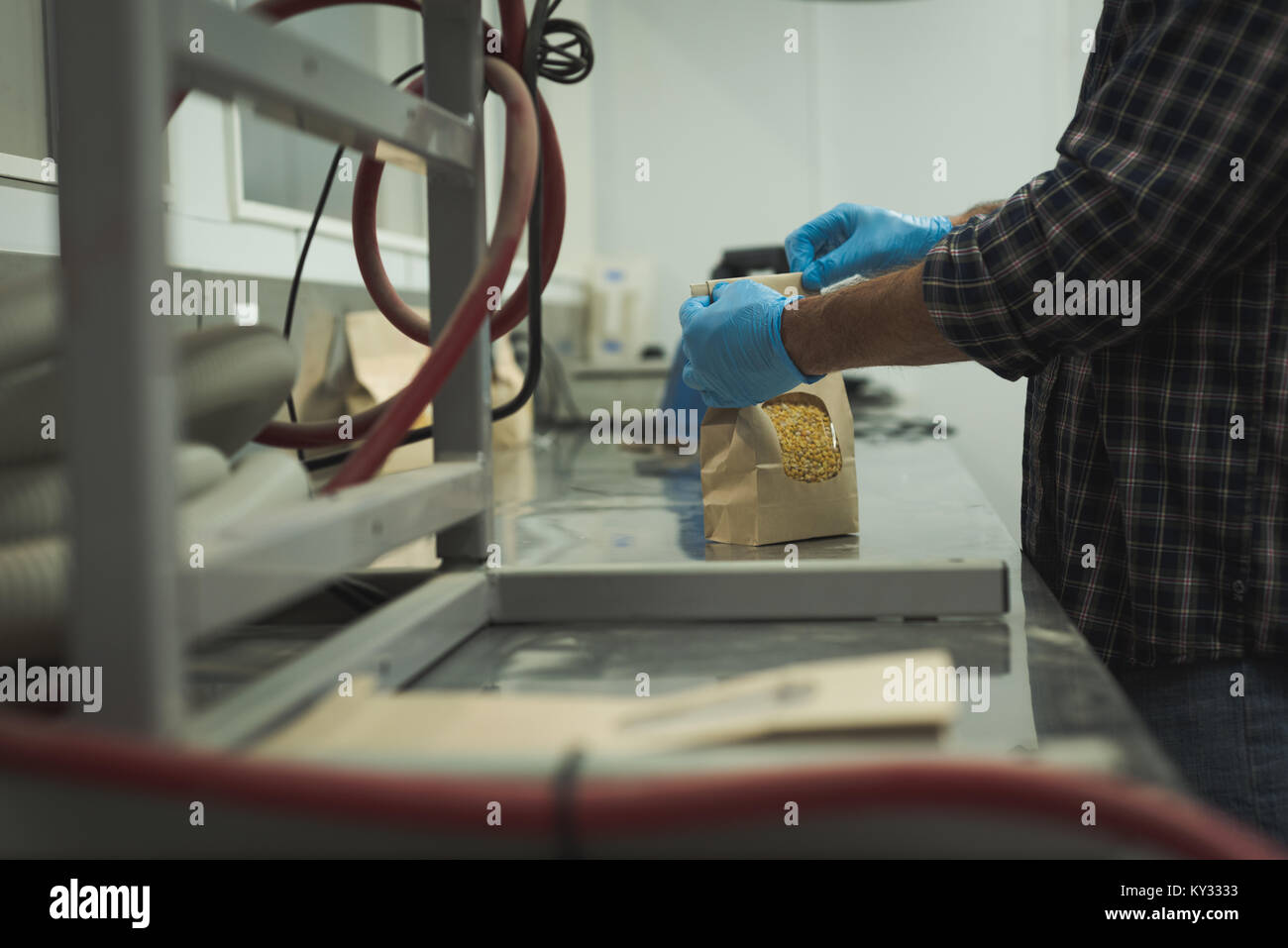 Man packing grains with machine Stock Photo - Alamy