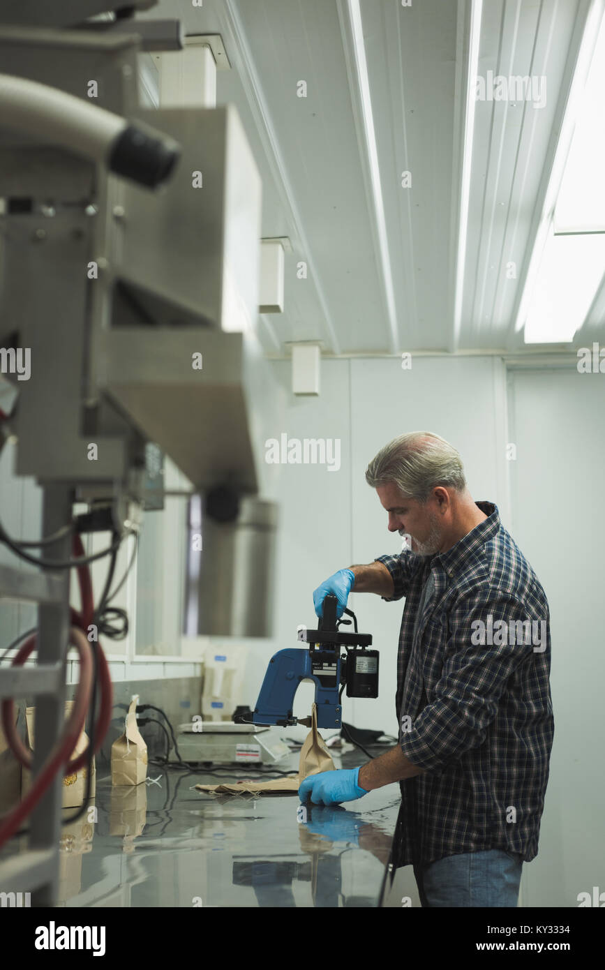 Man packing grains with machine Stock Photo - Alamy