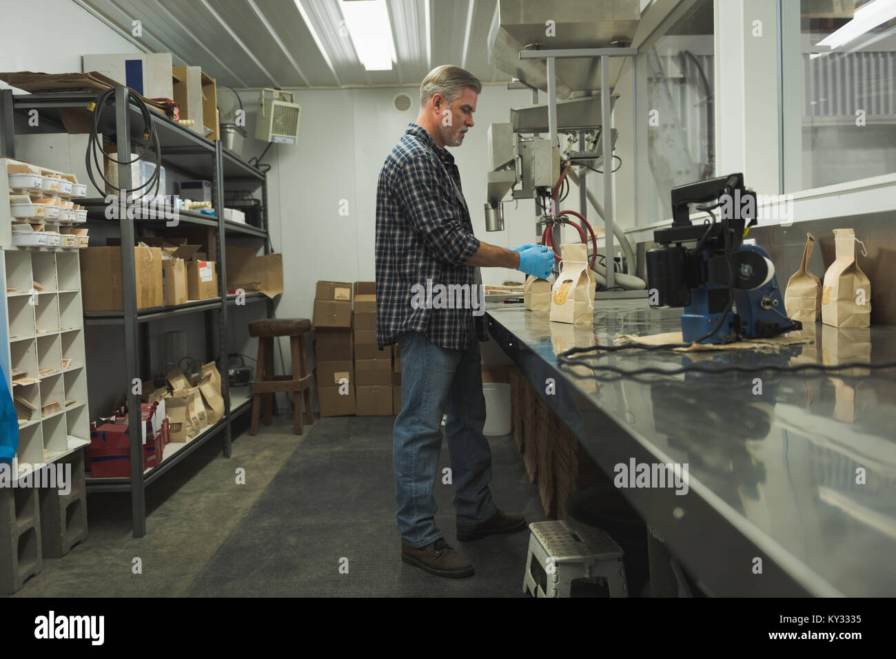 Man packing grains with machine Stock Photo - Alamy