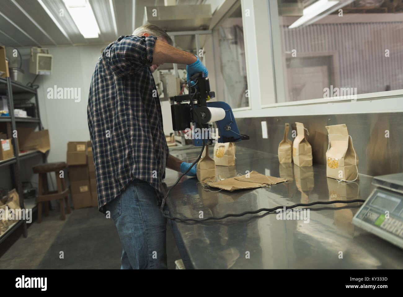 Man packing grains with machine Stock Photo - Alamy