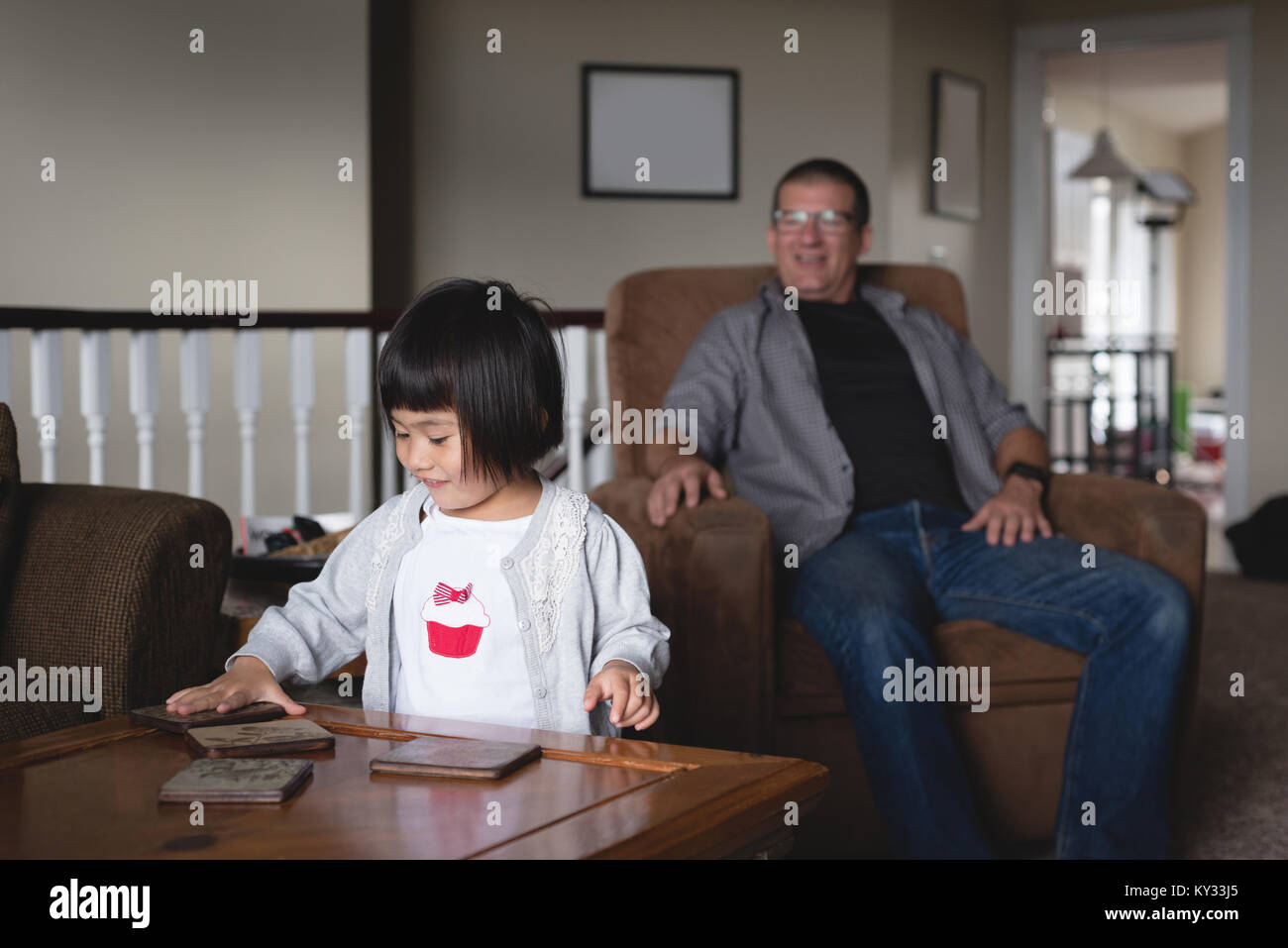 Girl standing near the table while father looking her Stock Photo - Alamy