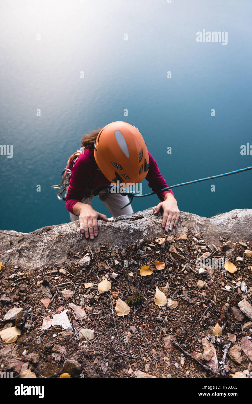 Rock climber reaching on the cliff top Stock Photo - Alamy