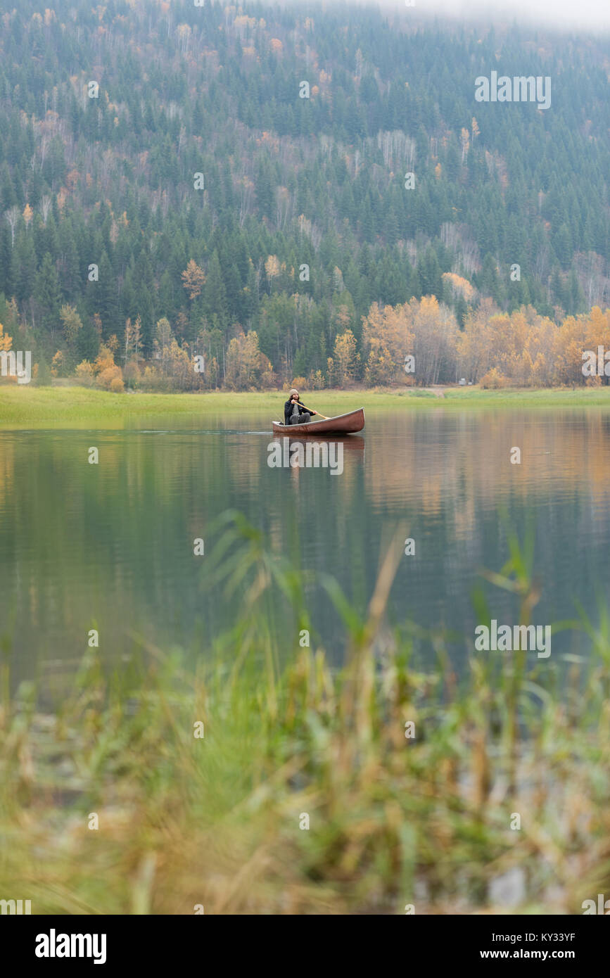 Man rowing canoe in silent river Stock Photo - Alamy