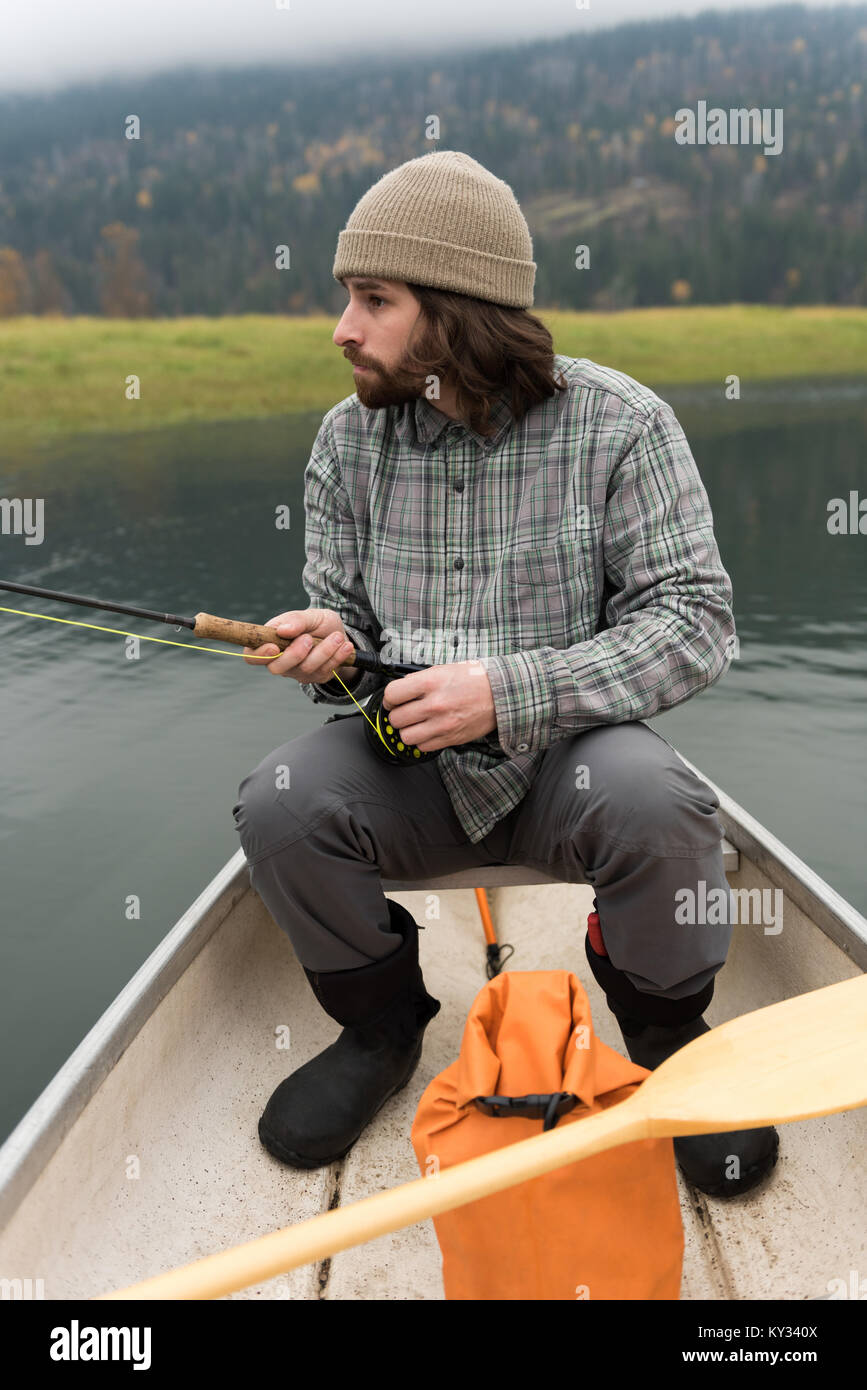 Fisherman with fishing rode on a boat Stock Photo - Alamy