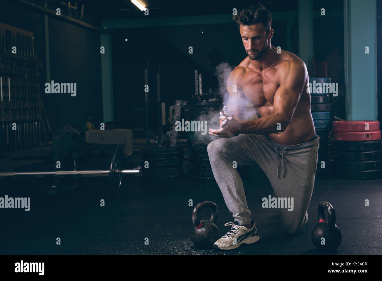Muscular man rubbing powder in hands Stock Photo - Alamy