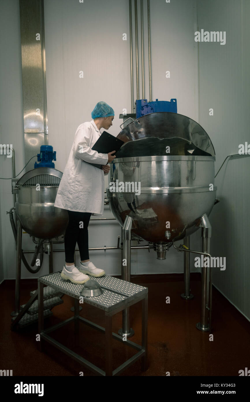 Female worker inspecting the food production line Stock Photo - Alamy