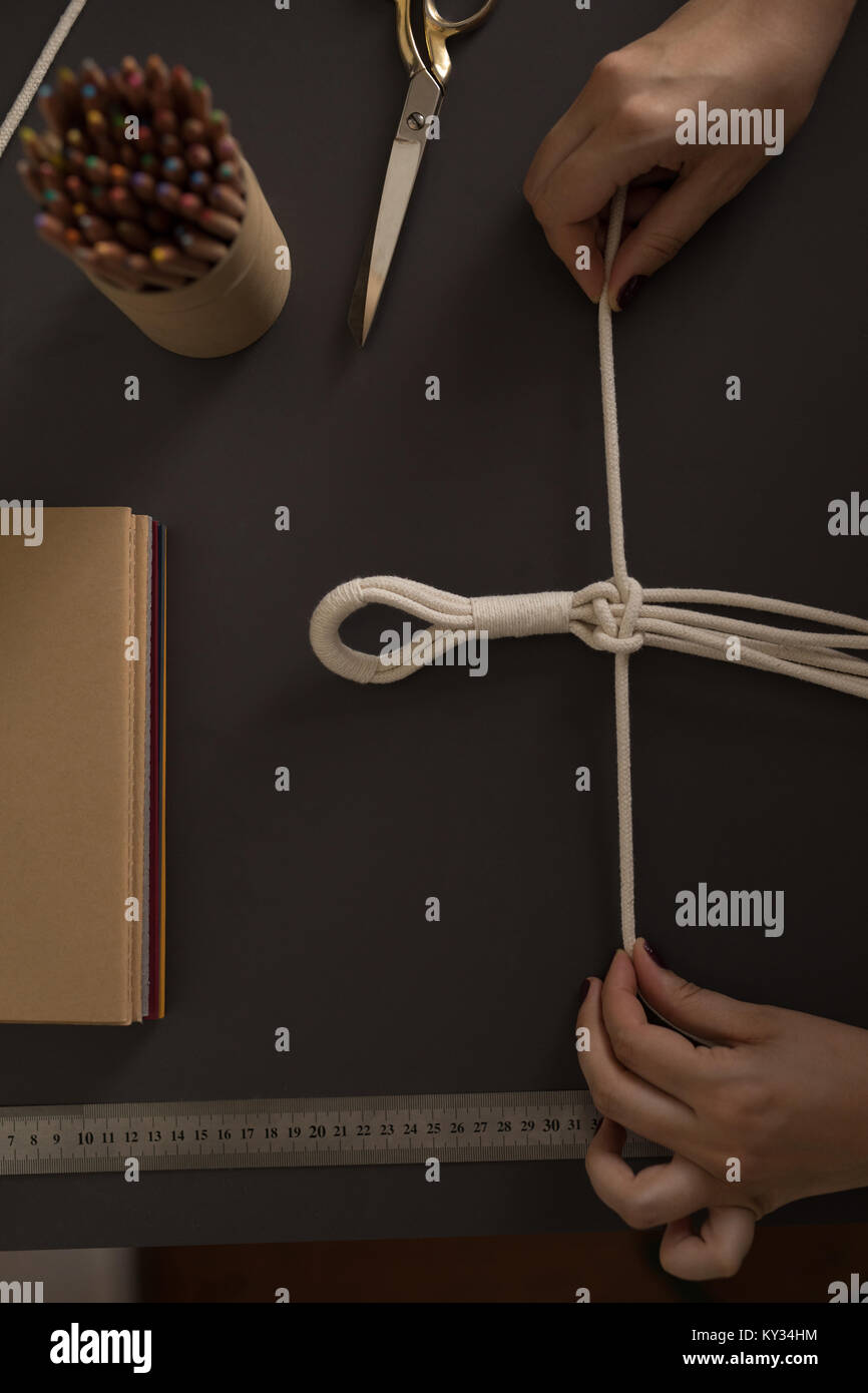 Woman knotting strings Stock Photo - Alamy