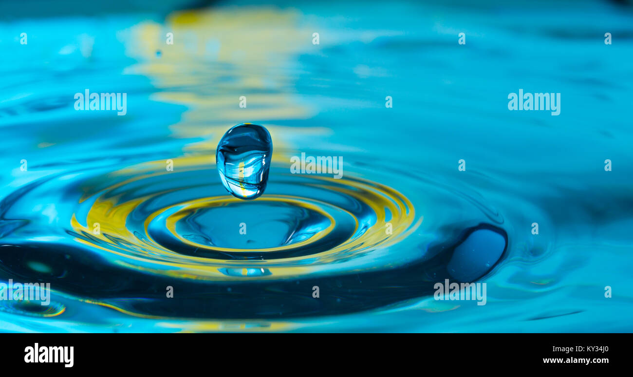 water drop splash in a glass blue colored Stock Photo - Alamy