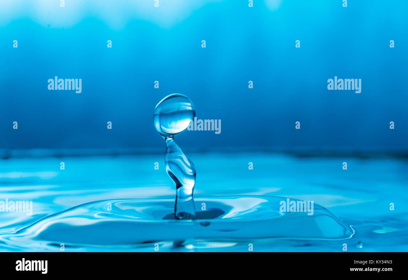 water drop splash in a glass blue colored Stock Photo - Alamy