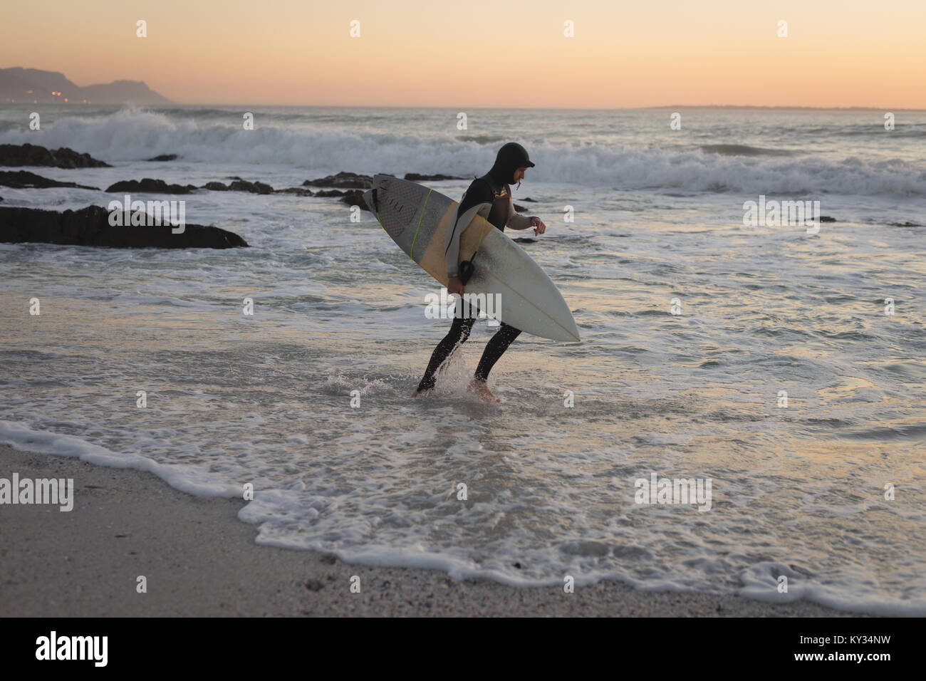 Surfer running with surfboard in sea Stock Photo - Alamy