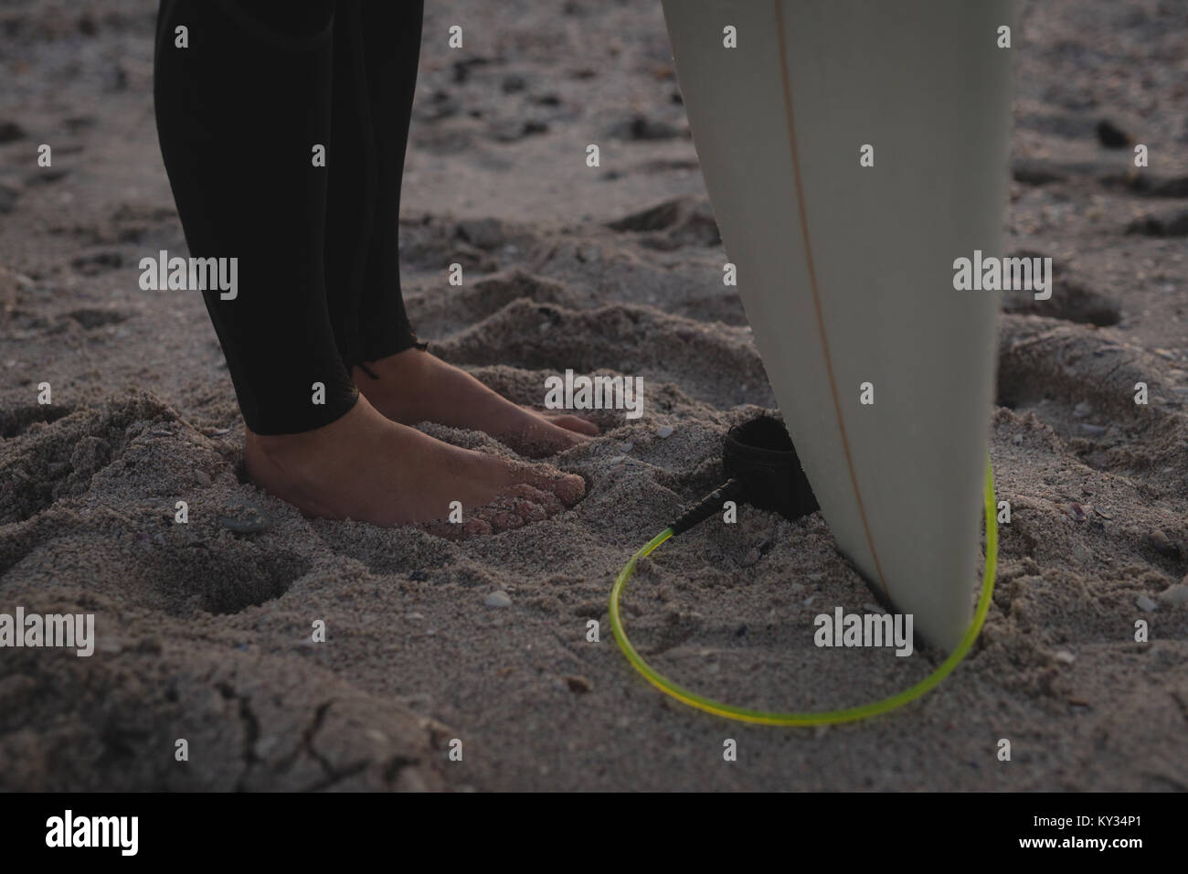 Surfer with surfboard standing on beach Stock Photo - Alamy