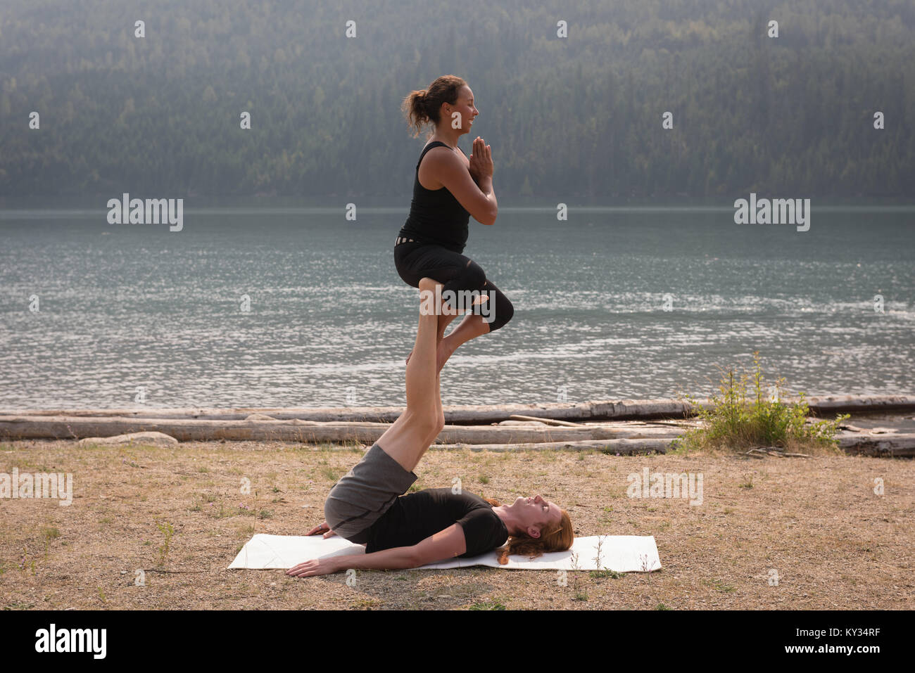 Sporty women practicing acro yoga on an open ground Stock Photo - Alamy